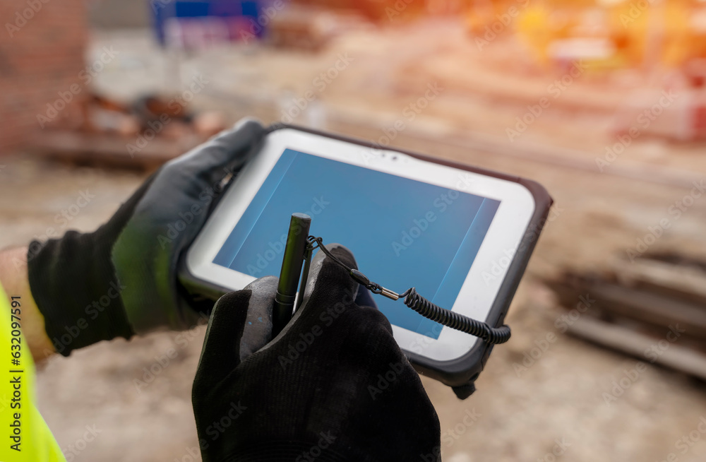 Site engineer surveyor using rugged tablet controller computer to ...