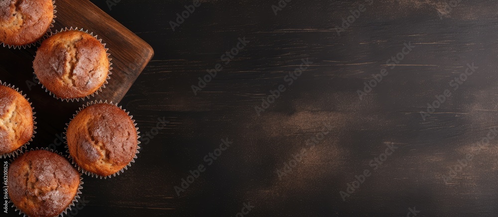 Homemade muffins placed on a dark textured background, view from above ...