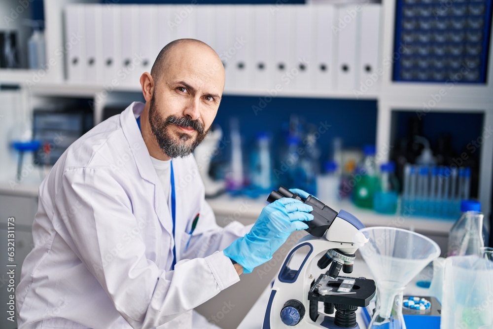 Young bald man scientist using microscope at laboratory Stock Photo ...