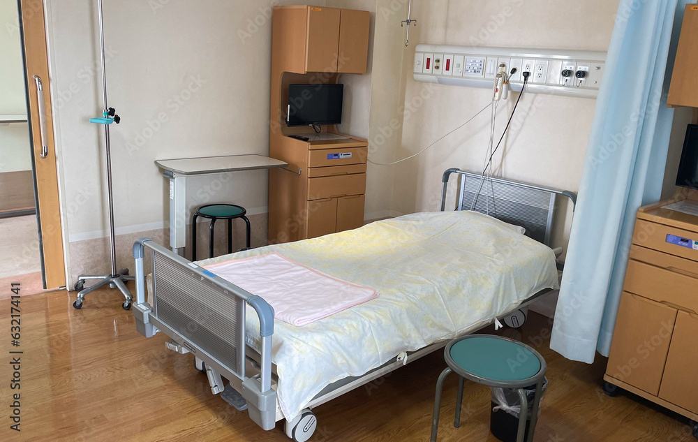 A multi-bed hospital room with an empty bed ready for a new patient ...