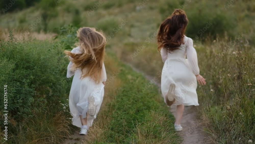 Two Girls In A White Dress Run On The Grass At Sunset Beautiful