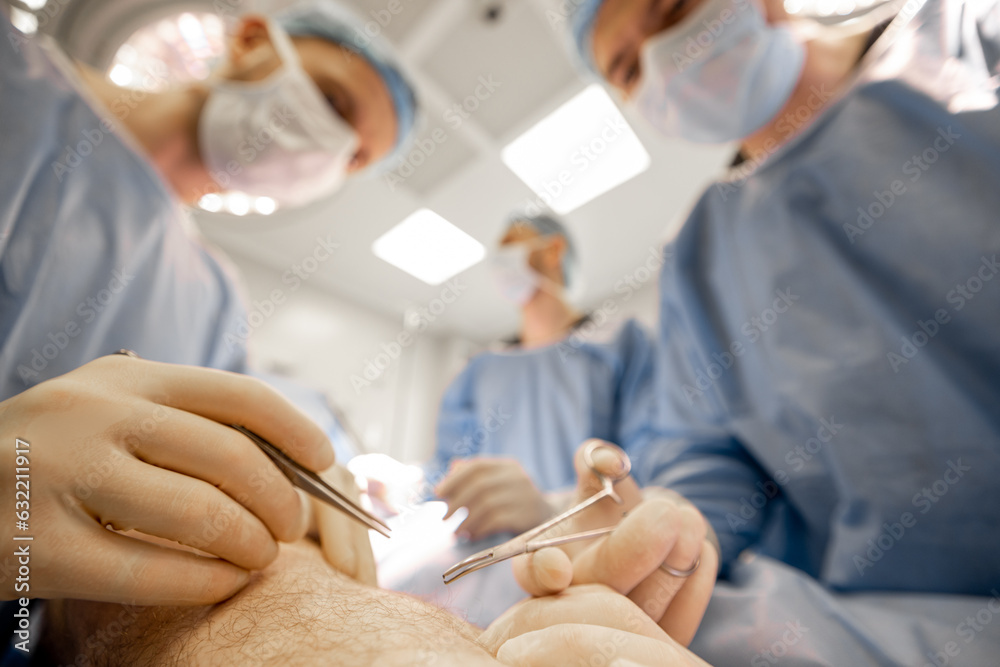 Surgeons performing surgical operation, wide view from below from the ...