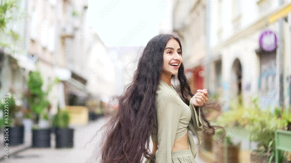 Beautiful young indian woman makes a beckoning gesture with one finger ...