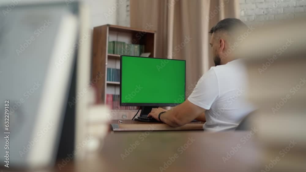 Man Working at His Desk Using Computer with Green Mock-up Screen ...