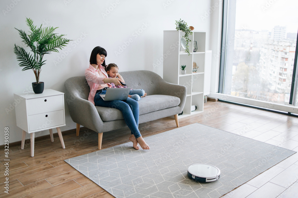 Young caucasian female with tween child using remote control for smart ...