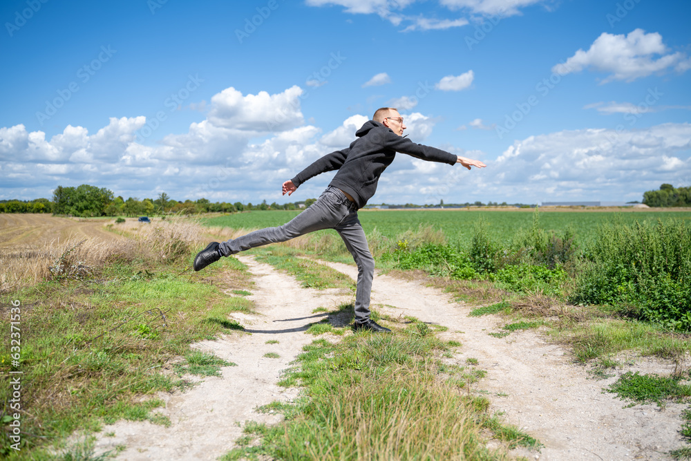 Jeune homme sur un chemin de terre lançant un cailloux Stock Photo ...