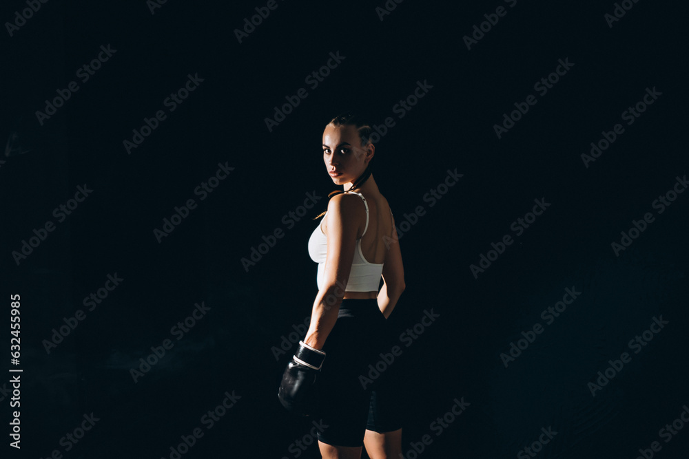 girl boxer standing in a confident pose surrounded by twilight. An ...