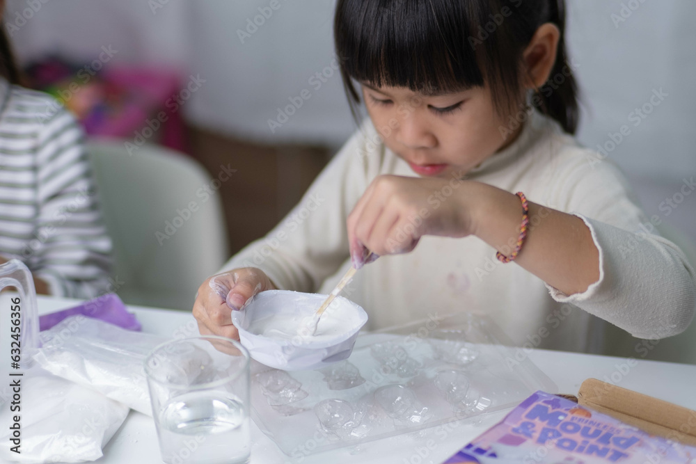 Cute little girl making DIY plaster and painting at home. Children ...