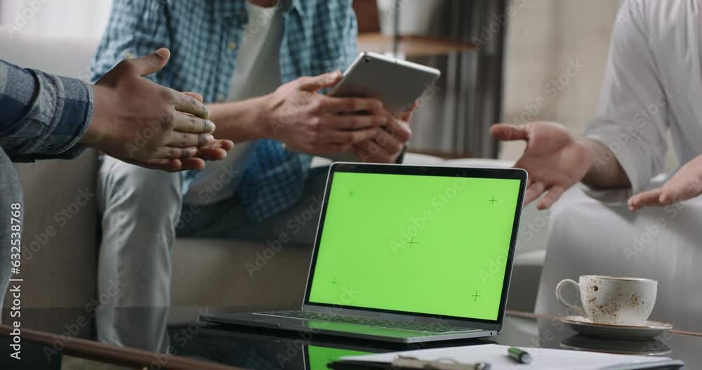 Green chroma key on laptop display. Young men shake hands, vigorously ...