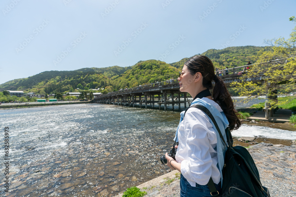 asian Japanese girl backpacker looking at calm Katsura river under ...