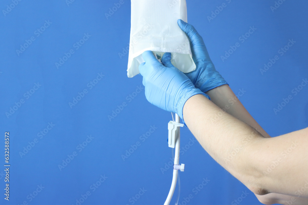 Professional wearing gloves adjusting the saline bag in the arterial ...