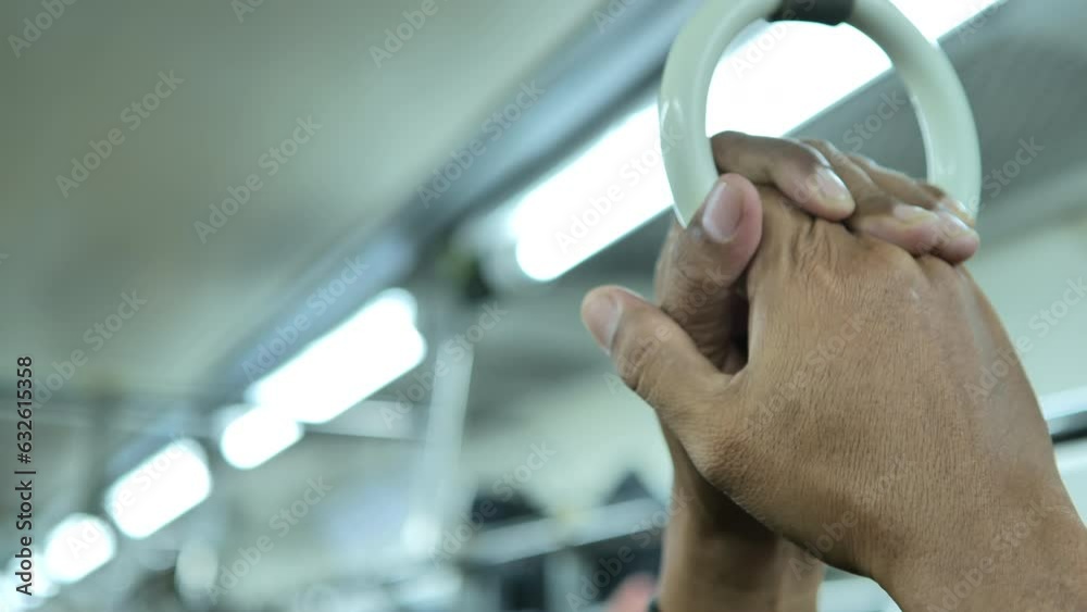 The hand of a standing train passenger grasping the handrails of a ...