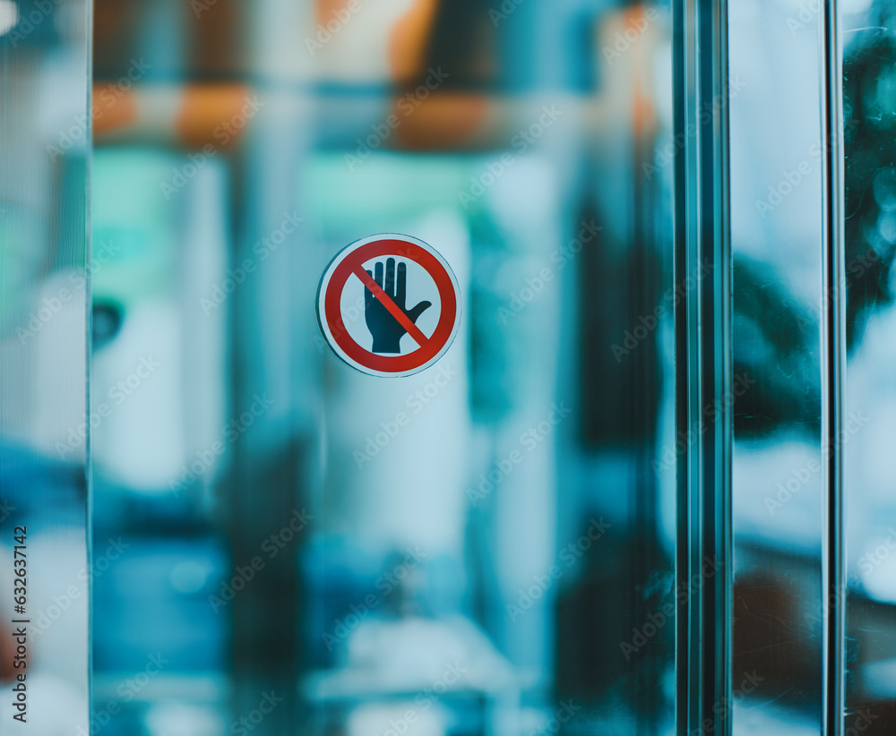 Stop hand warning icon for don't touch sign on glass door in modern ...