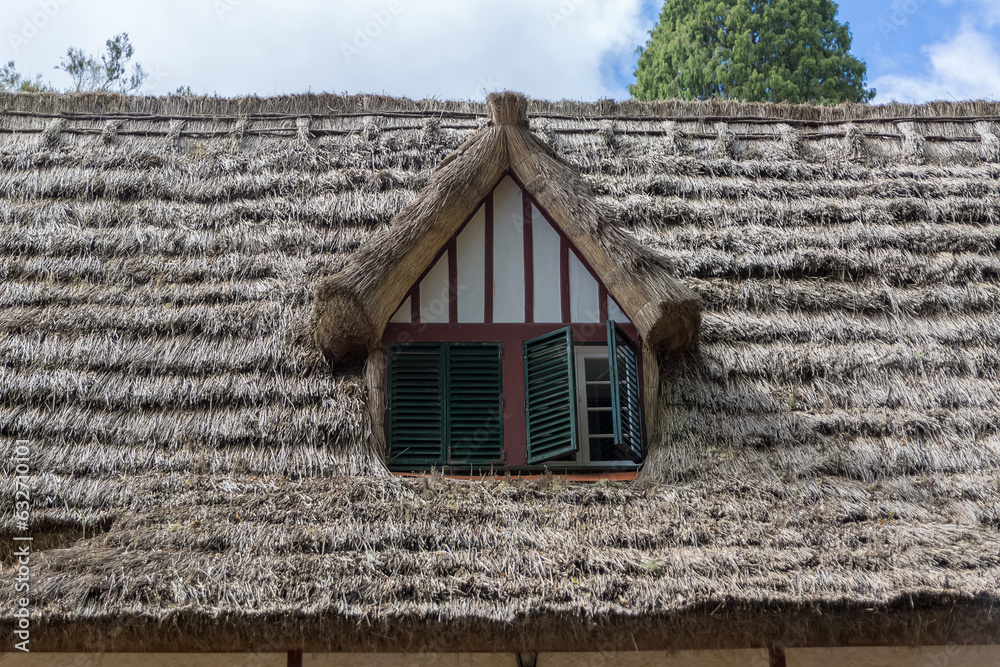 Detail view of a traditional thatched roof and window, used on ...