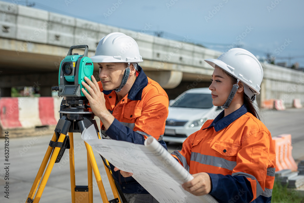 Teamwork of construction surveyors. A construction worker using ...
