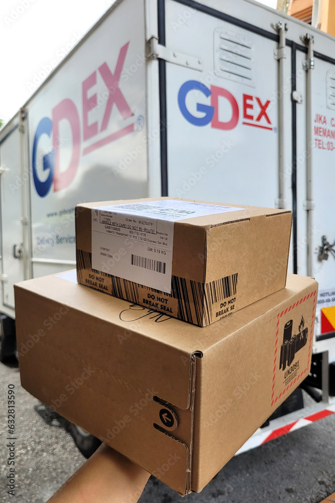 PENANG, MALAYSIA - 17 JULY 2023: An Asian man receiving a parcel box shipped by GDEX for his ...