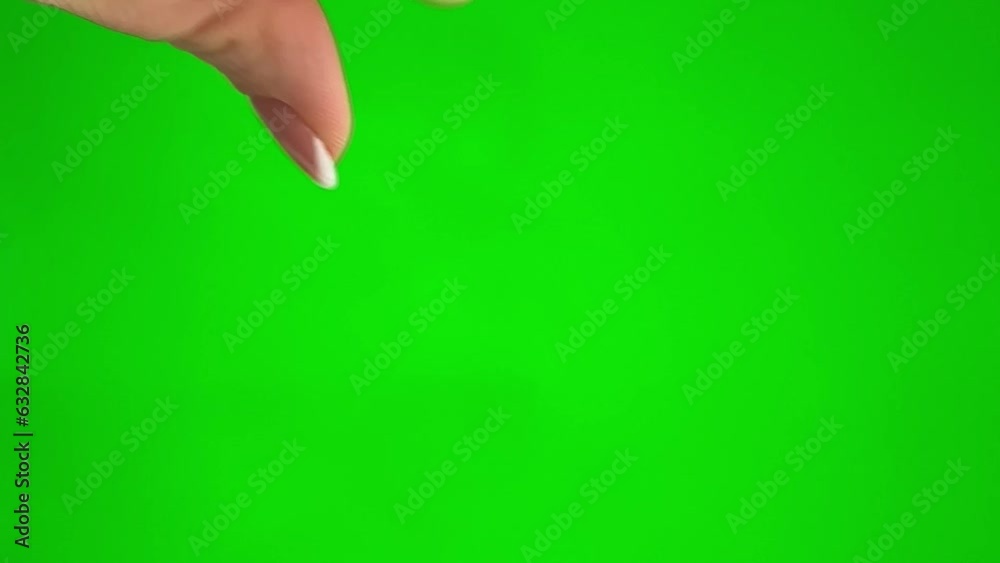 female hands smooth the frame on which Green background chroma key you ...
