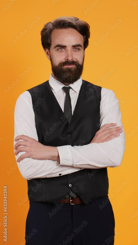 Vertical video Refined waitstaff member poses happily in front of ...