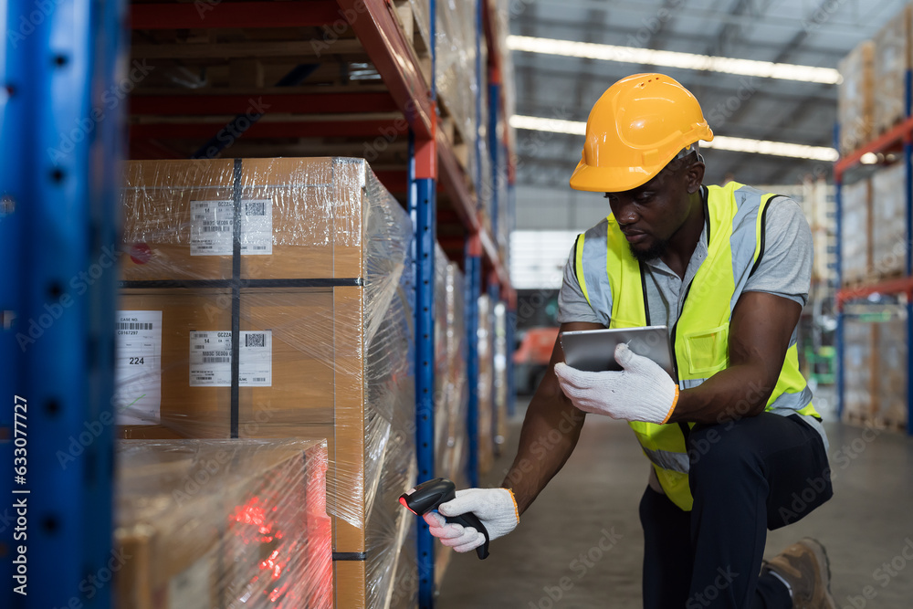 African American male warehouse worker scanning barcodes on boxes on ...
