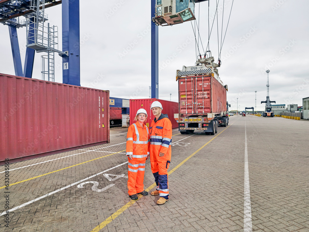 train dock worders talking while cargo is loaded to lorry waiting by ...