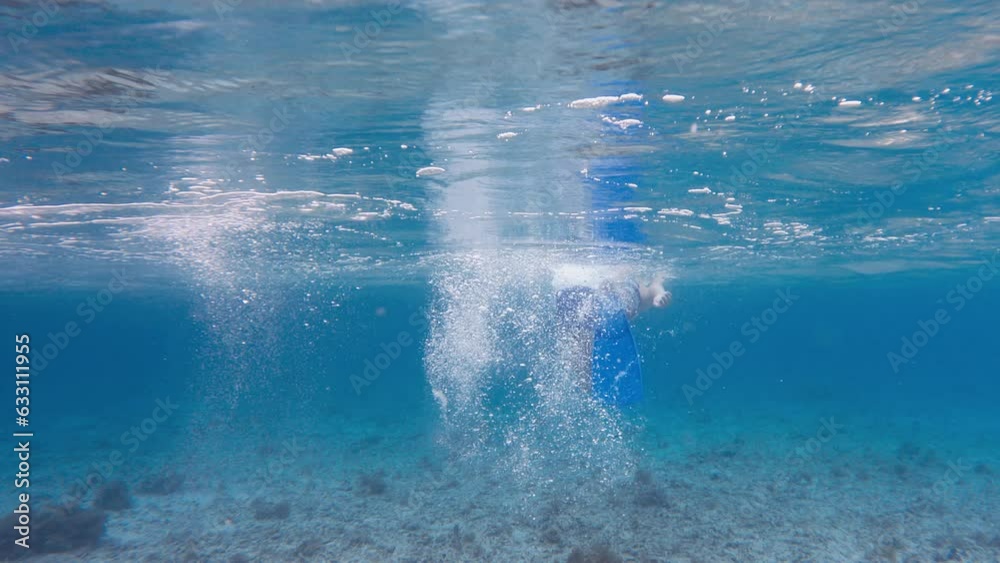 Following a man free diver with blue flippers swimming underwater of ...