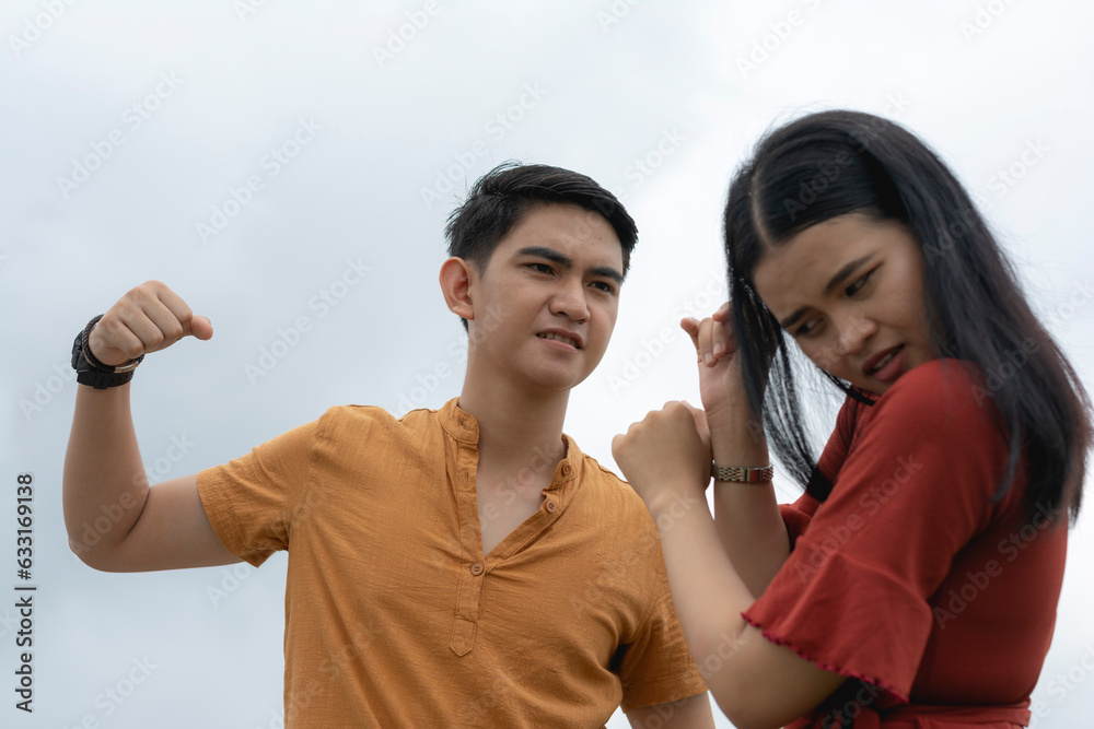 An angry young asian man threatens to punch his girlfriend. Example of ...