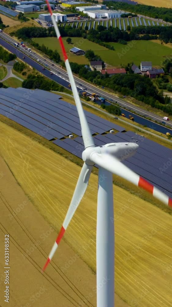 Solar panel cells and rotating wind turbines on the green energy farm ...