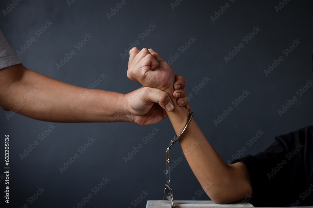 Poster Close-up of hand holding kid hands with handcuffs, child was a ...