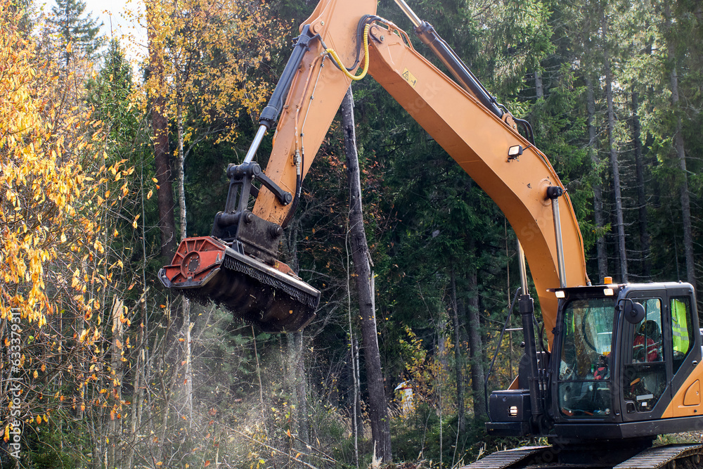 Wood chipper is chopping wood on side of road using mulching attachment ...