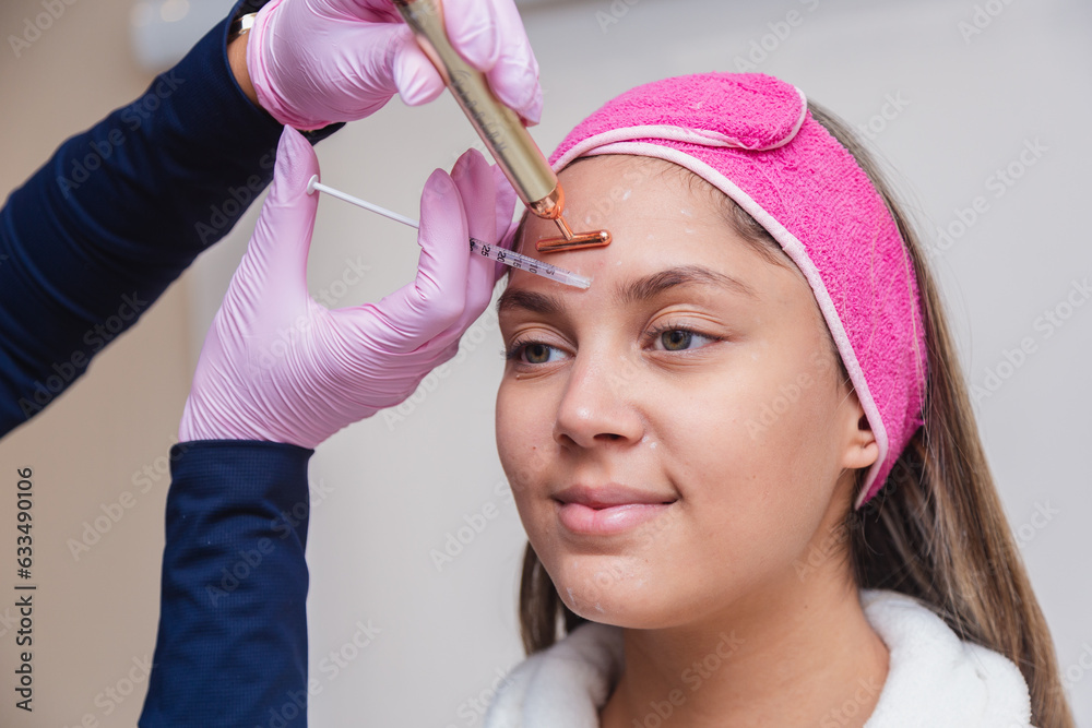 Aesthetics professional, with a patient, performing botulinum toxin ...