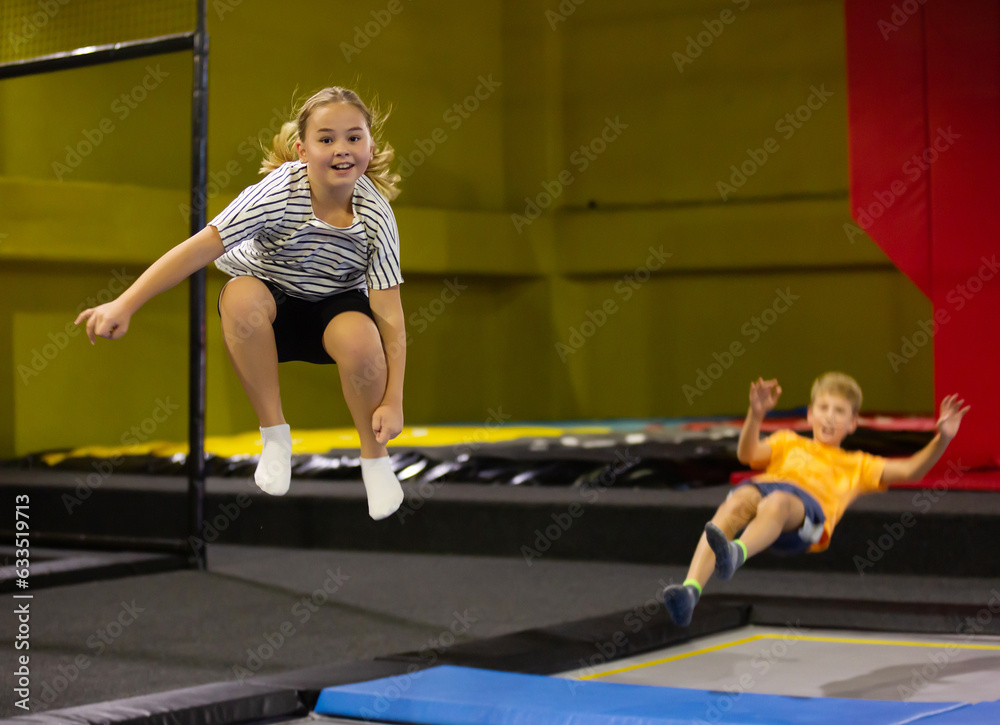 Happy emotional tween girl having fun in indoor amusement park ...
