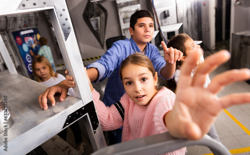Portrait of tween girl holding out her hand to something in escape room ...