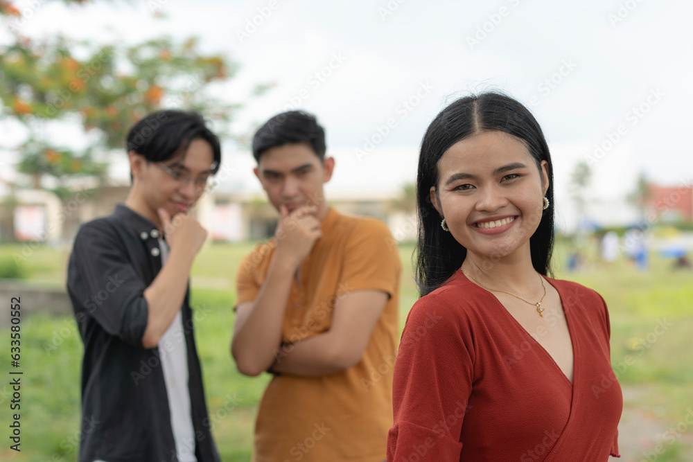 A young asian woman is happy getting attention from two young men ...
