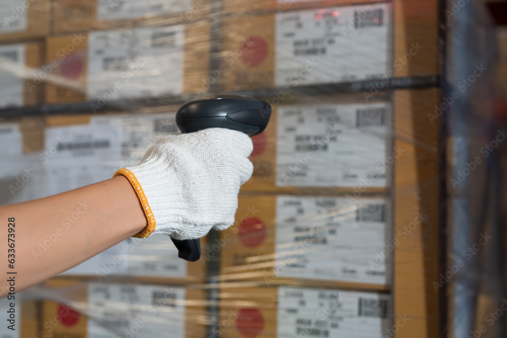 Hand of warehouse worker scanning barcodes on boxes on shelves pallet ...
