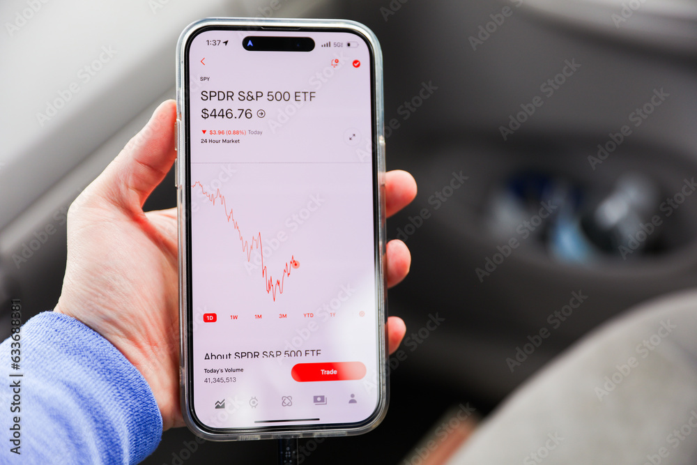 stock market financial turbulence, a hand checks a phone amidst rising ...