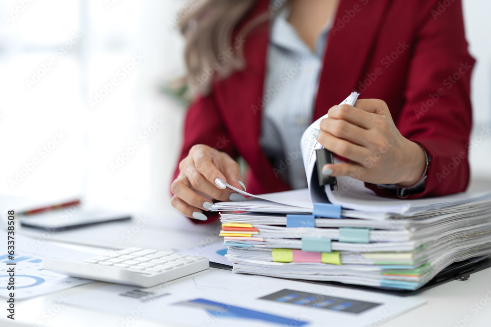 Businesswoman working in piles of paper files Data graph document to ...
