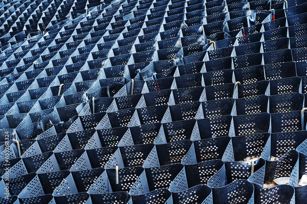 Plastic geogrid for strengthening soil and slopes. Material laid in ...