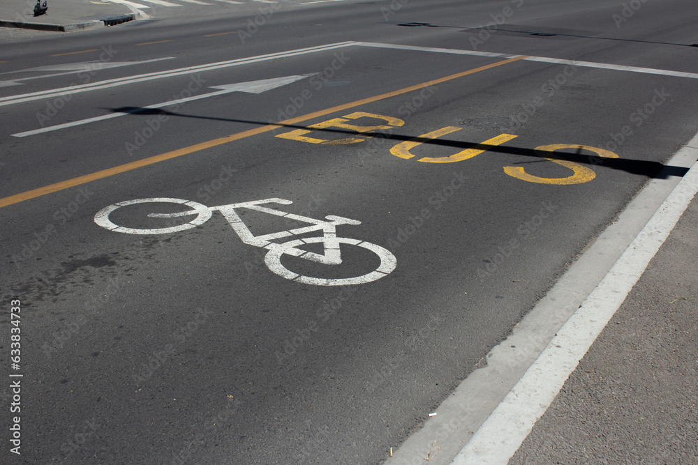 Yellow bus line sign on an gray asphalt road. Road marking with bicycle ...