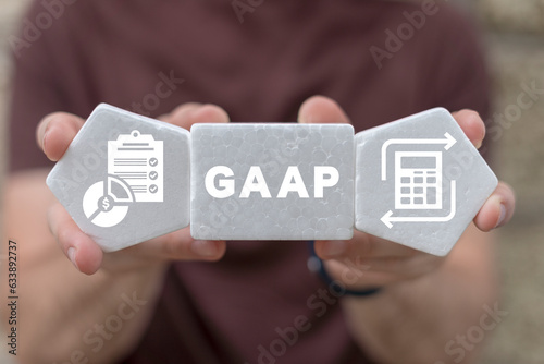 Man holding white plastic foam blocks with icons and sees acronym: GAAP ...
