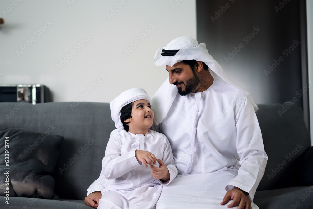 Emirati UAE father and son together at luxury home living room. Arab ...