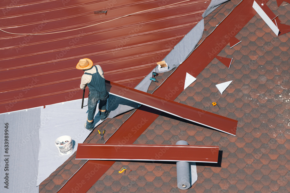 Professional construction worker changing the roof membrane of a ...