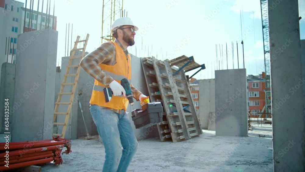 Happy construction worker at construction site dancing with boxtool and ...