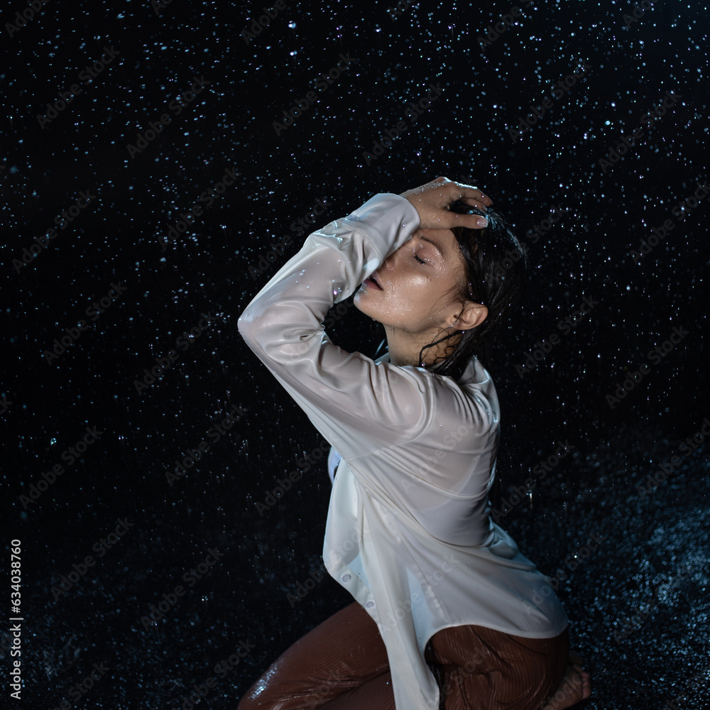 young woman in the rain, getting wet through, wet clothes and water ...