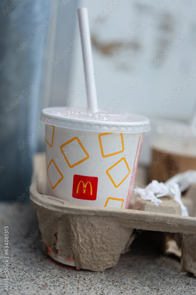 discarded McDonald's cup with straw sitting inside a cardboard drink ...