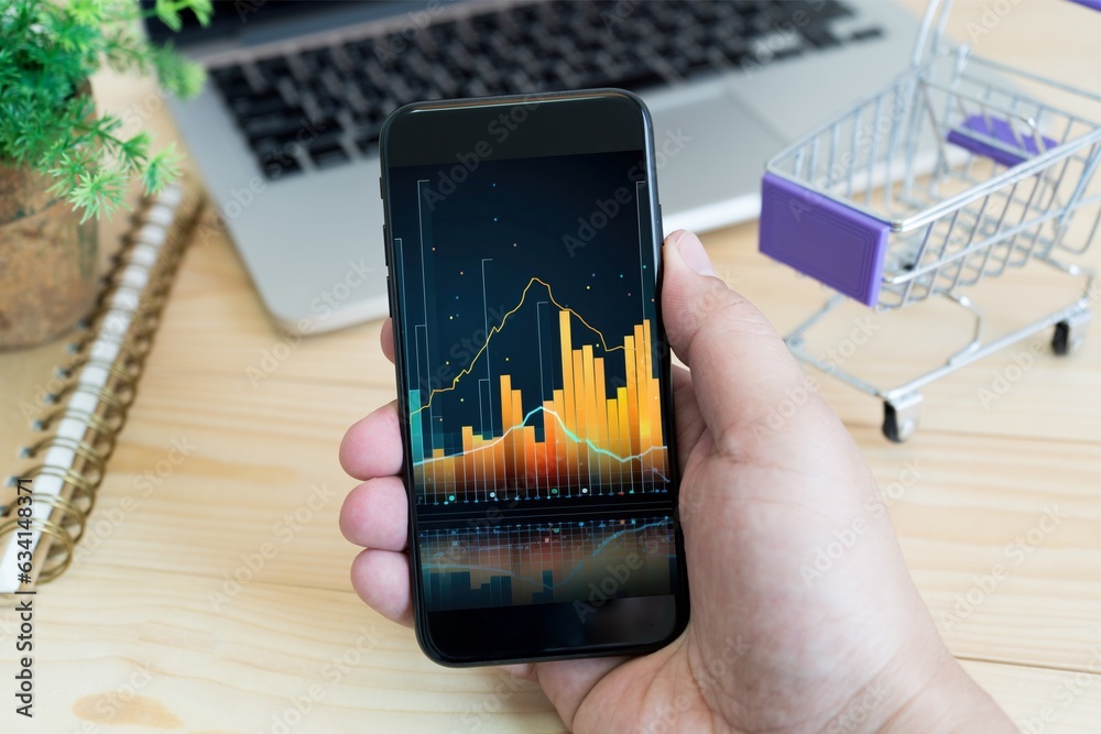 Hombre sosteniendo en su mano su teléfono móvil analizando sus gastos y evolución de sus ...