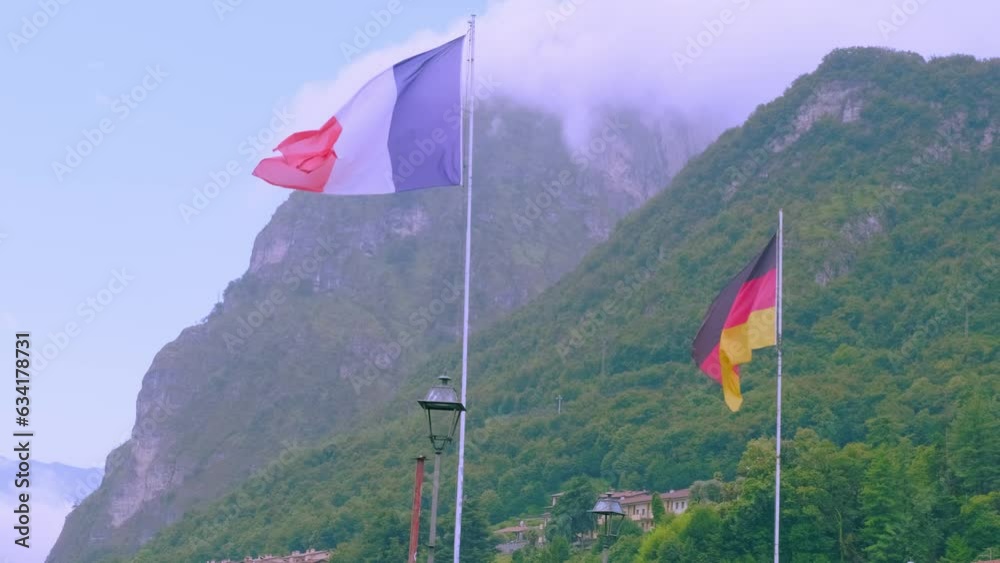 silk national flags of france, Germany flutters in foothills, concept ...