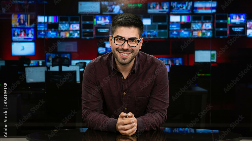 man with glasses in television studio smiling looking at camera ...