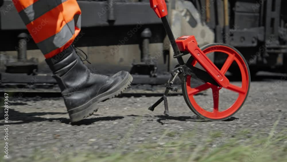 Roadway repair. Man measuring length of repairing road. Construction of ...