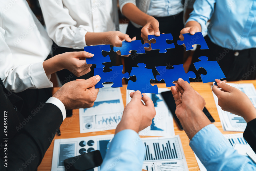 Multiethnic business people holding jigsaw pieces and merge them ...