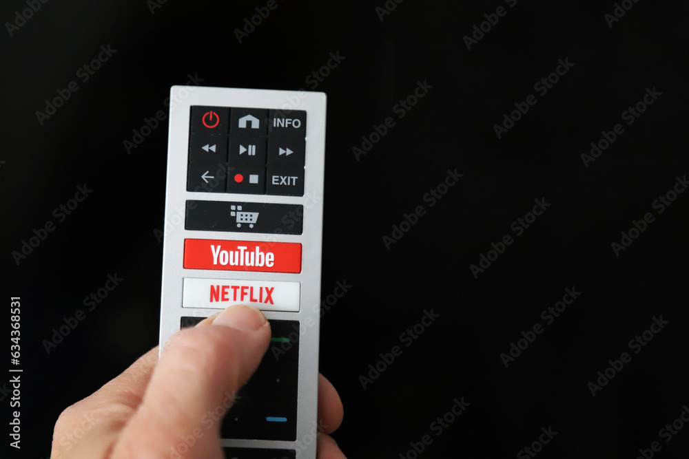 Hand with smart TV remote control by pressing Netflix or Youtube button ...